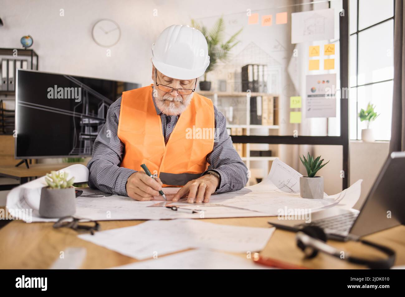 Senior builder, engineer in reflective vest uniform and hard hat on ...