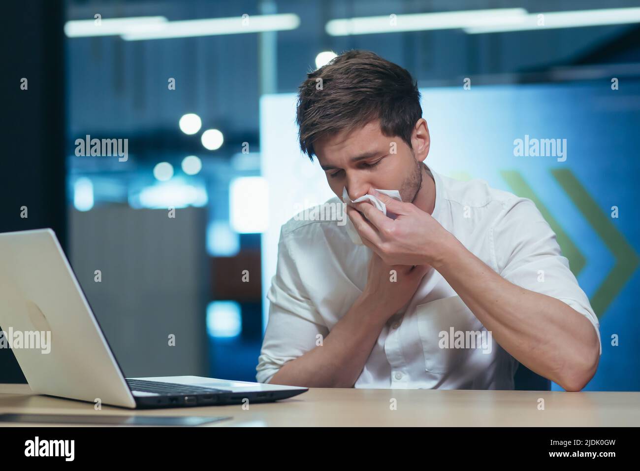 Feeling unwell in the workplace. Young handsome male businessman ...