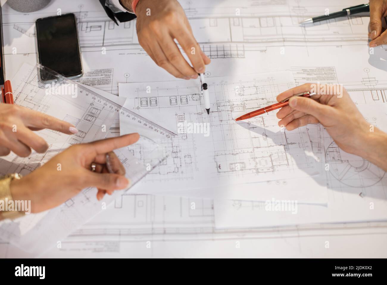 Close up of architects, engineers and designers sitting together at ...