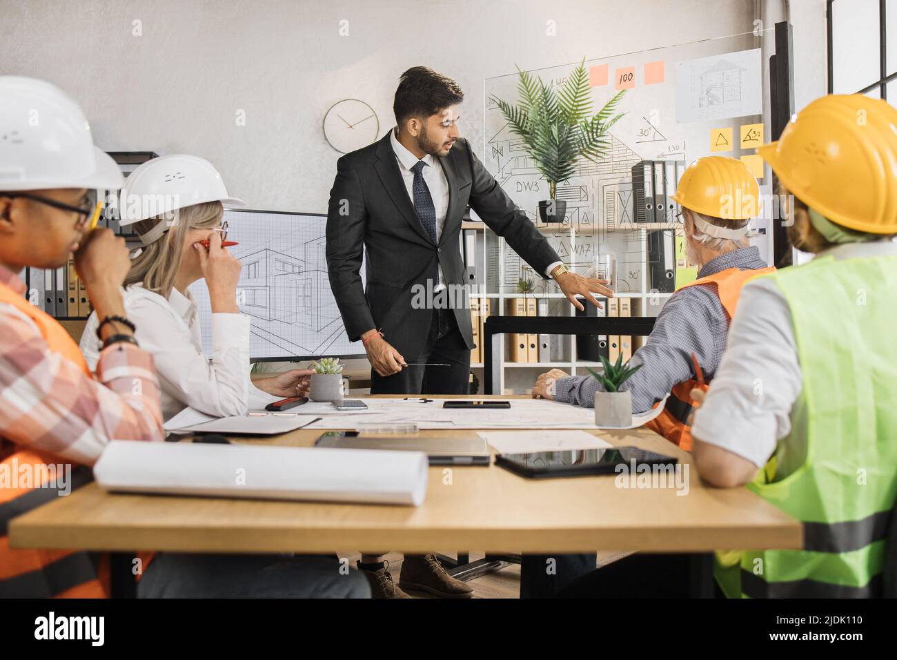 Group of five multiracial people wearing formal clothes and helmets ...