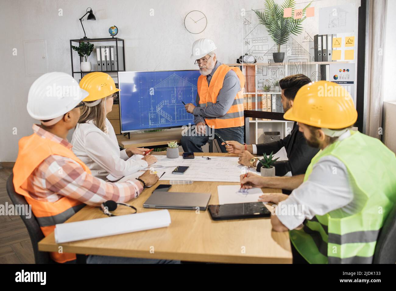 Mature builder caucasian man talks about the project on big lsd monitor ...