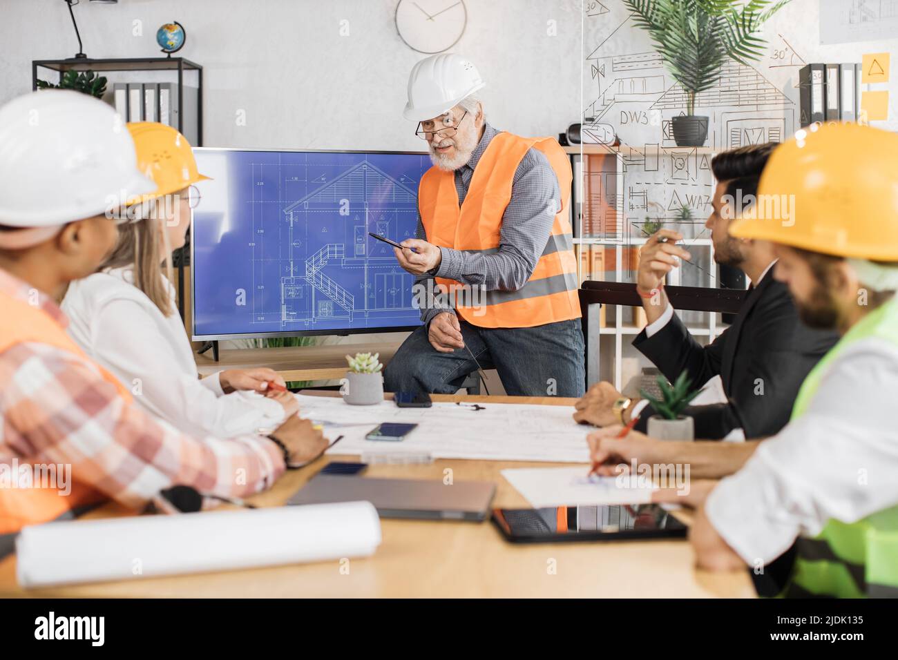 Mature builder caucasian man talks about the project on big lsd monitor ...