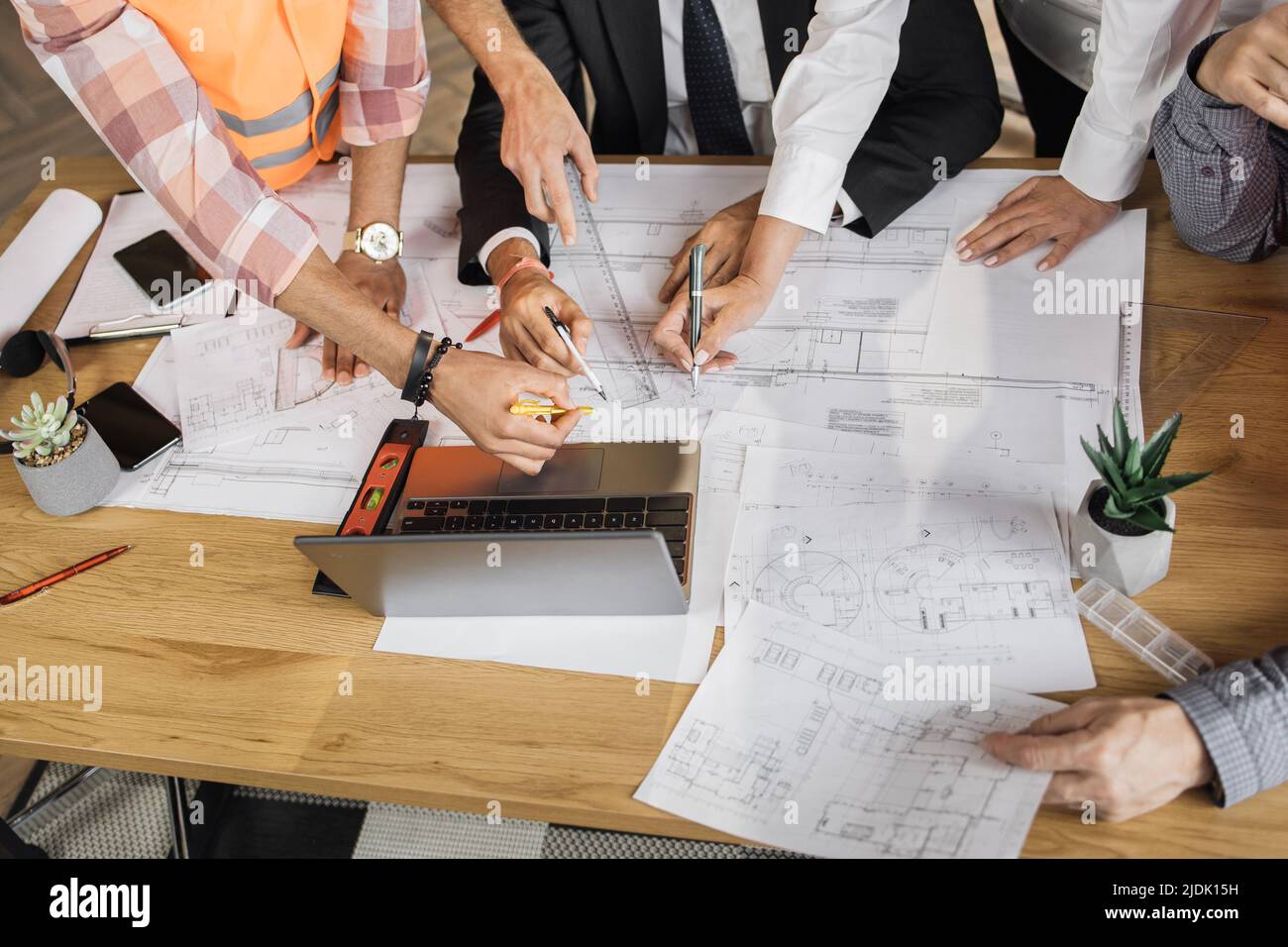 Close up of architects, engineers and designers sitting together at ...