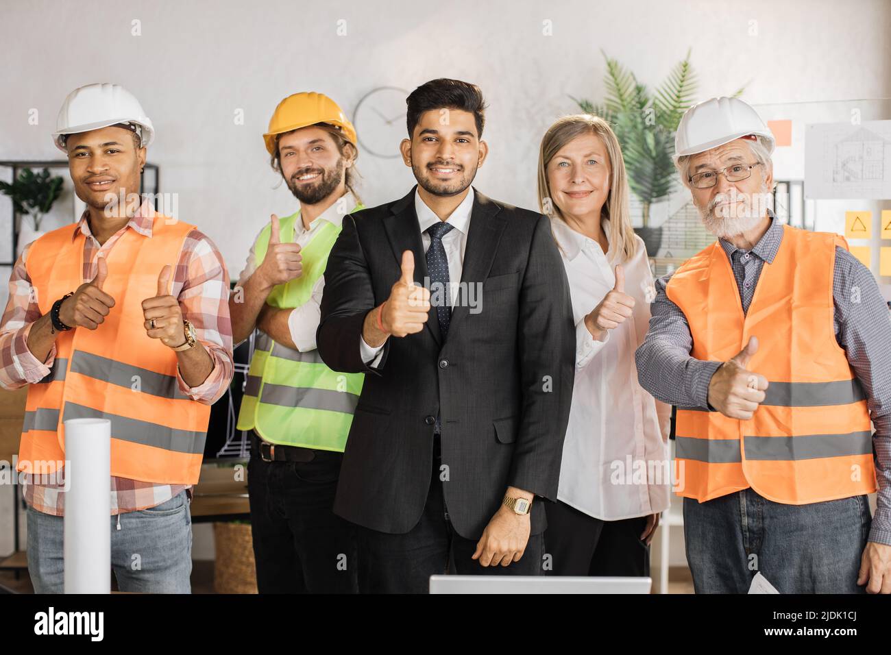 Front view of one senior woman and four men engineers, builders ...