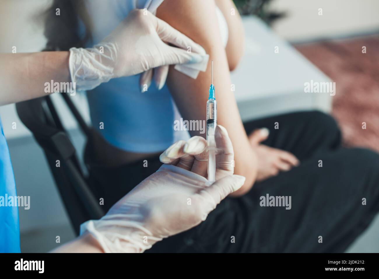 Medical assistant's hand disinfecting patient's arm preparing to give ...