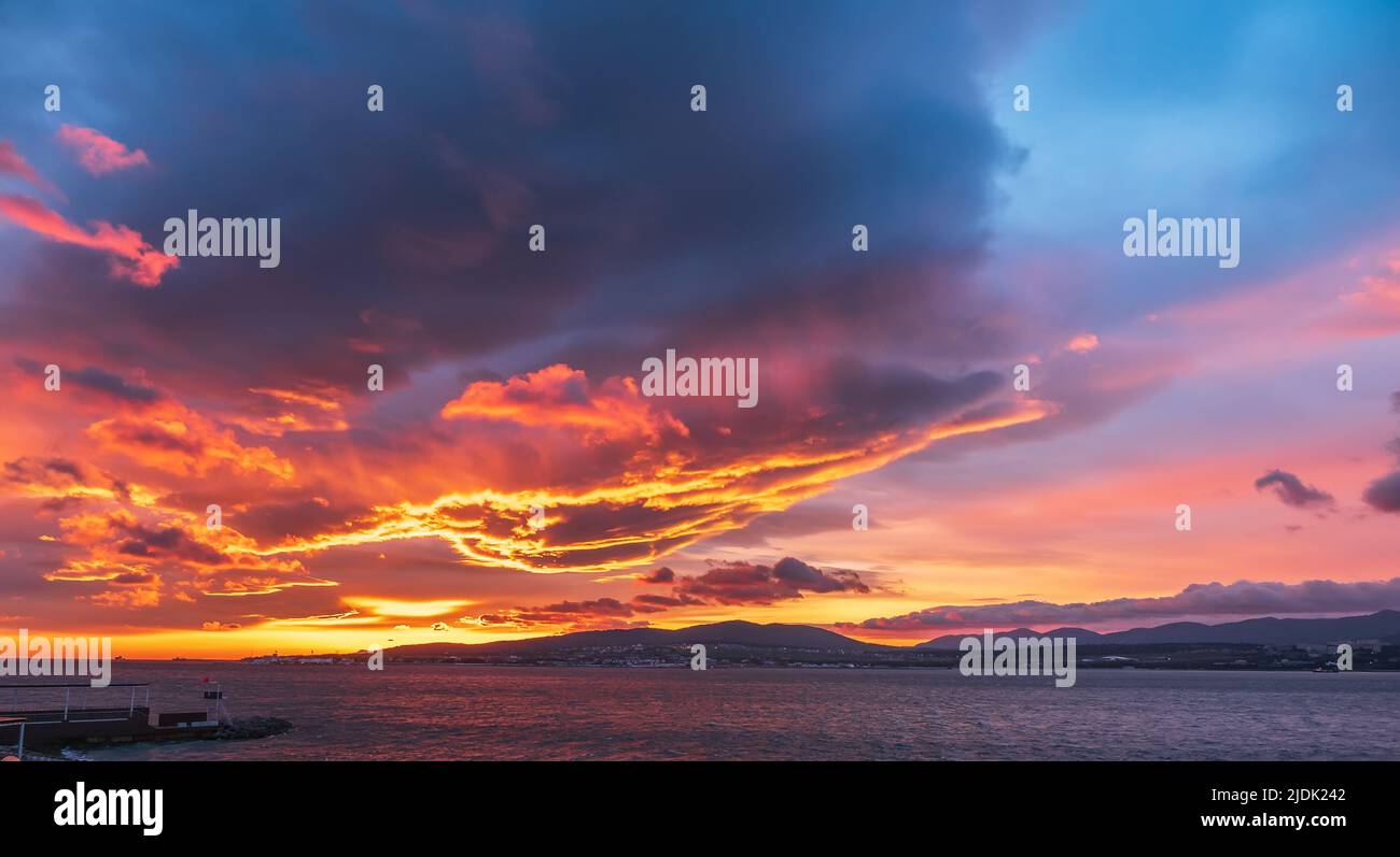 Sunset sky with red orange and violet-blue clouds over sea Stock Photo ...