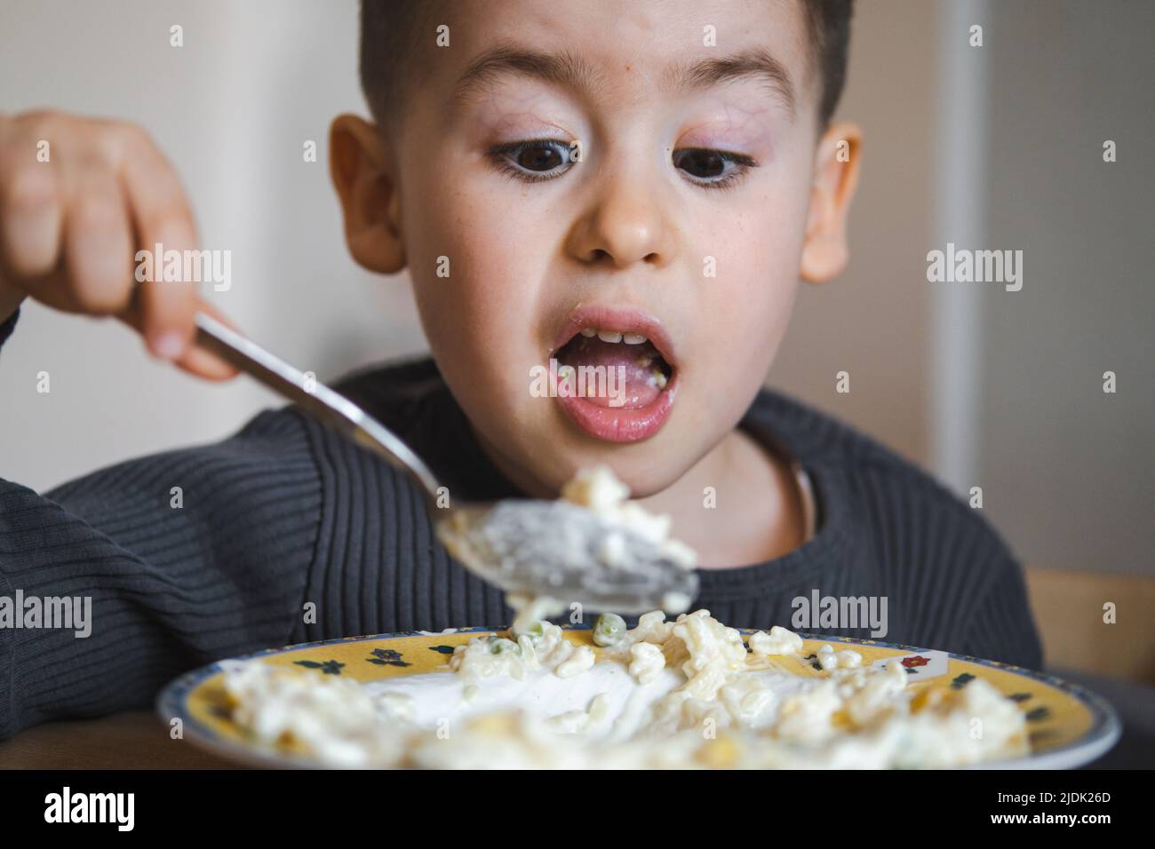 Toddler eating independently eating cereal puree with spoon. Healthy ...