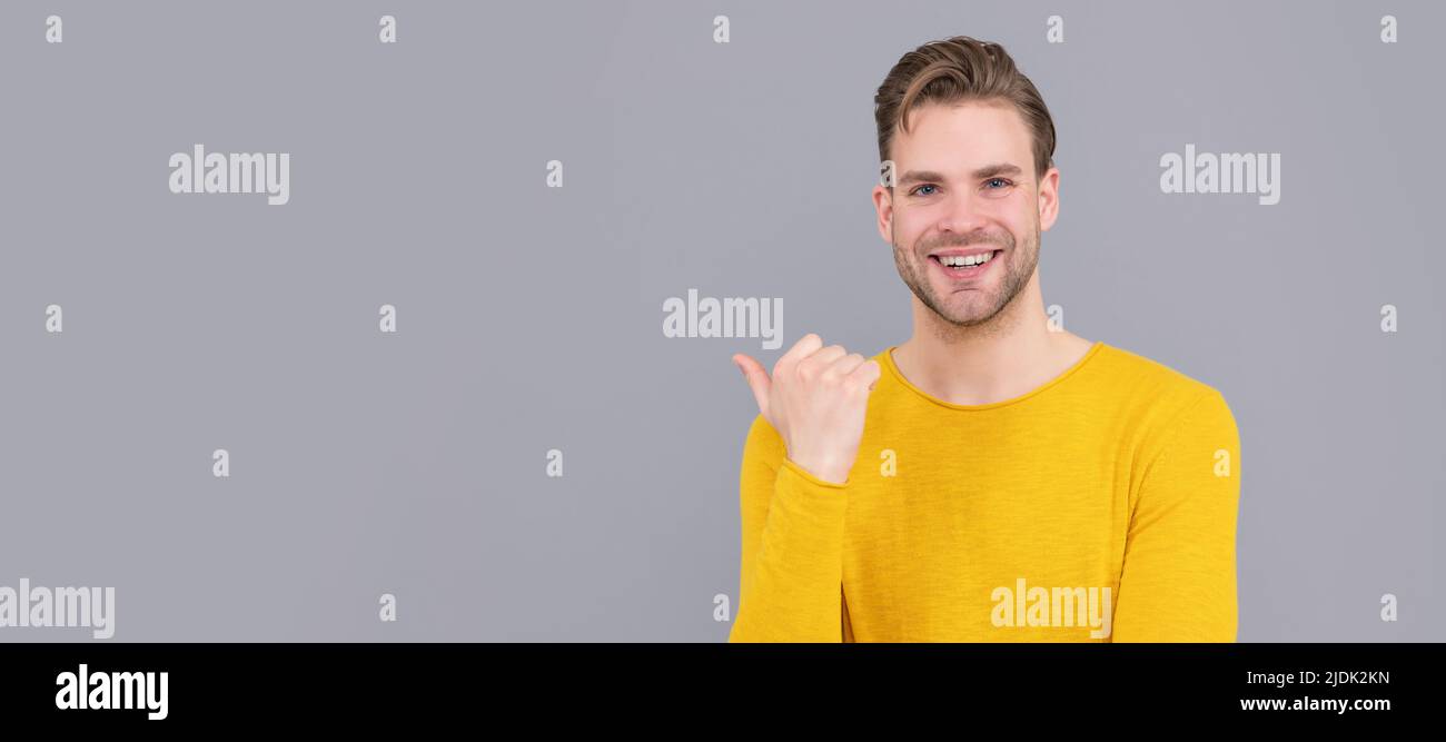 Advertising. Advertising man. Happy guy point finger aside grey ...