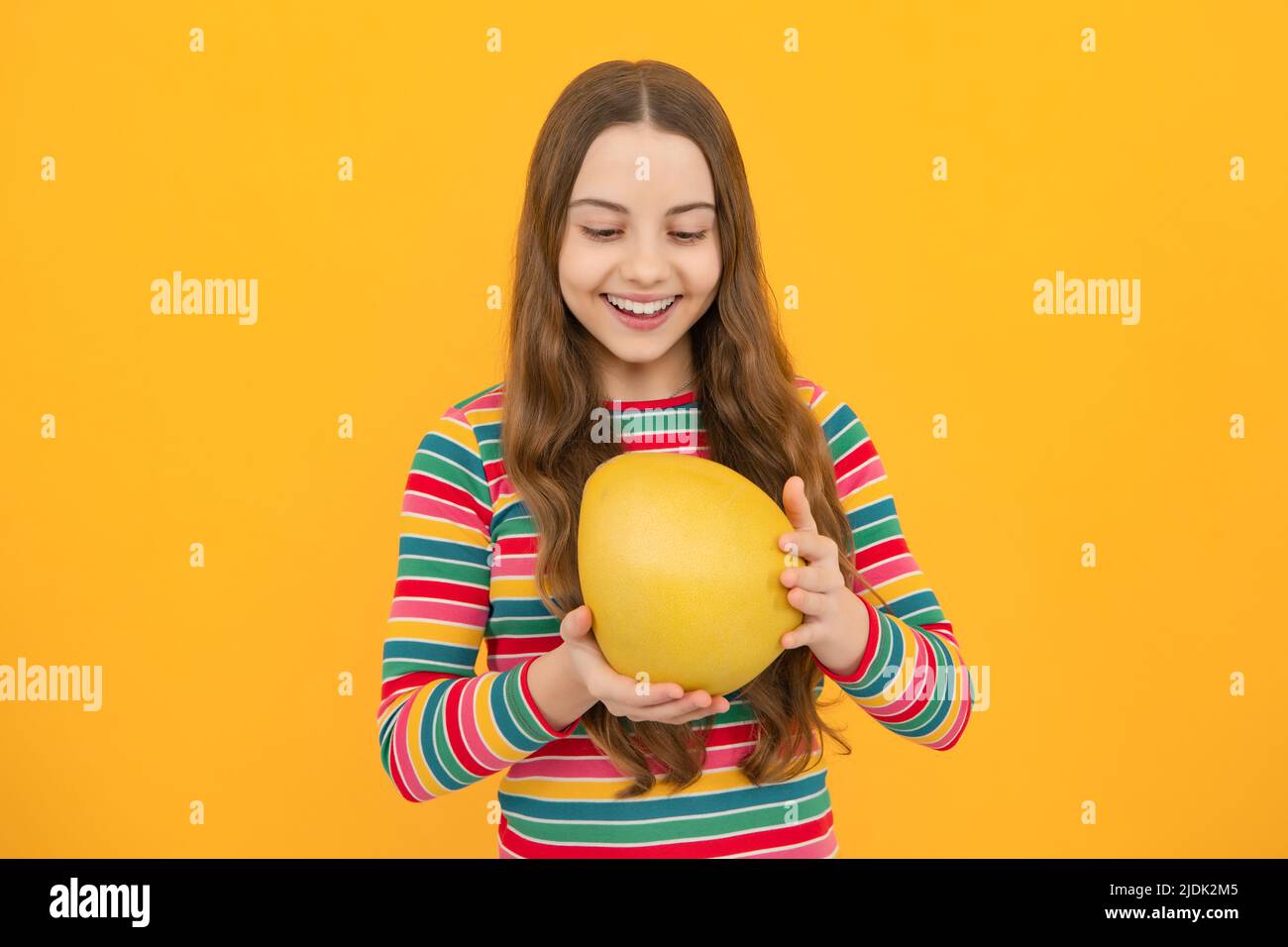 Teenager child girl hold citrus fruit pummelo or pomelo full of vitamin ...