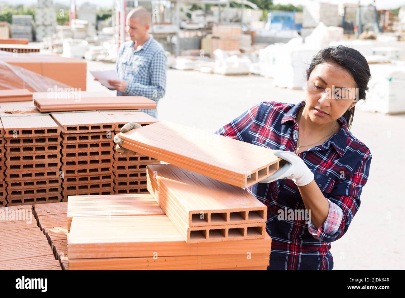 Female worker stacking bricks in warehouse of materials Stock Photo - Alamy