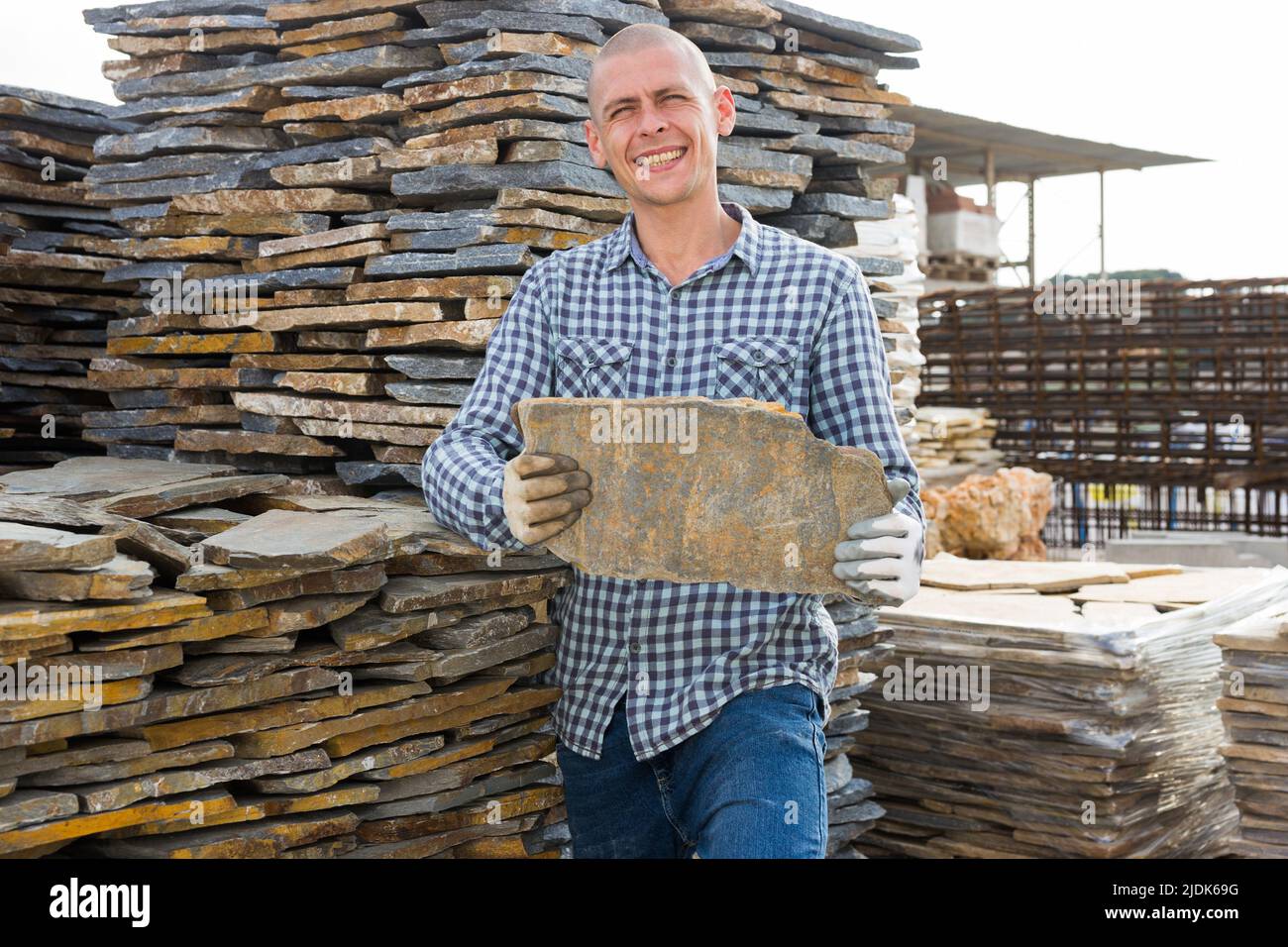 Male worker checking quantity of natural stone tiles in warehouse Stock ...