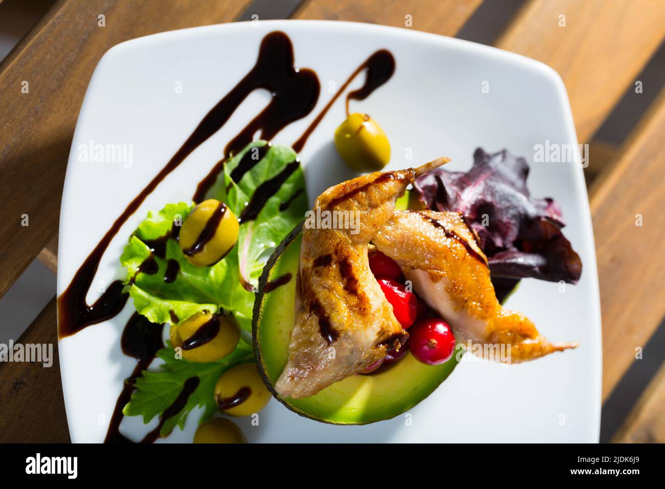 Broiled quail legs with avocado, cranberries, greens, balsamic Stock ...