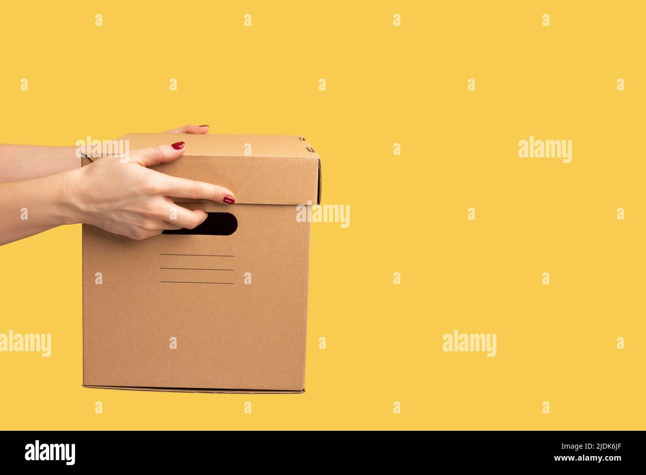 Profile side view closeup of human hand holding cardboard box, carton ...