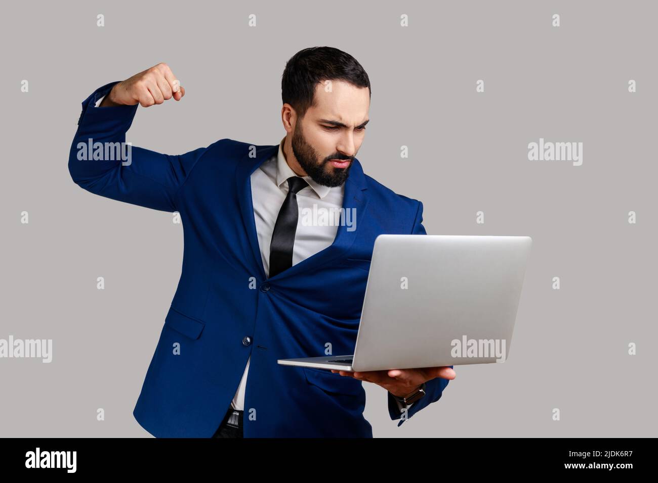 Man punching laptop screen, looking with furious mad expression, boxing ...