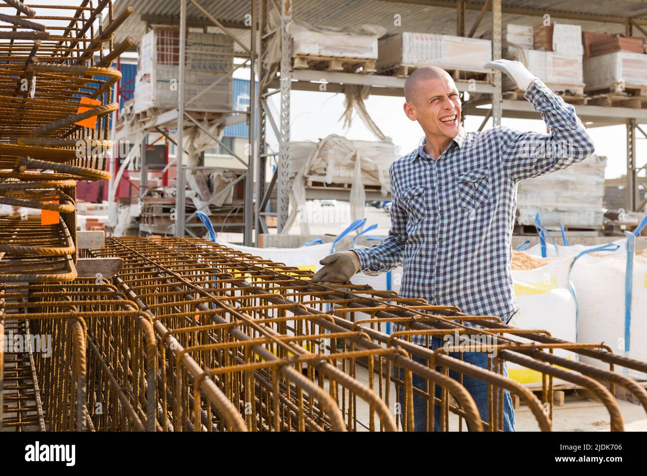 Construction shop worker prepares metal rebar for loading onto truck ...