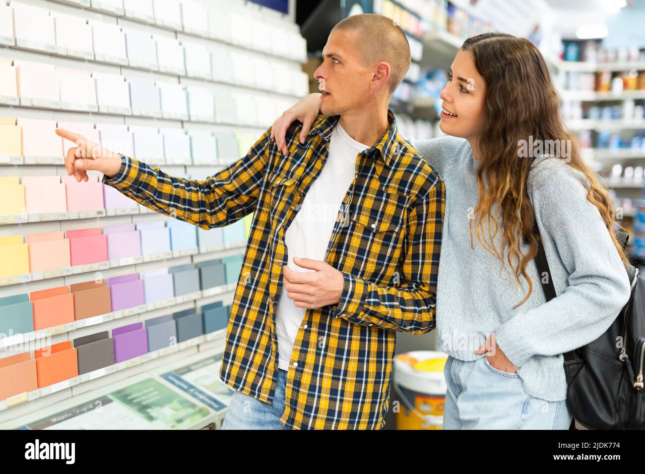 Woman and man consumer choosing tiles color samples in hardware store ...