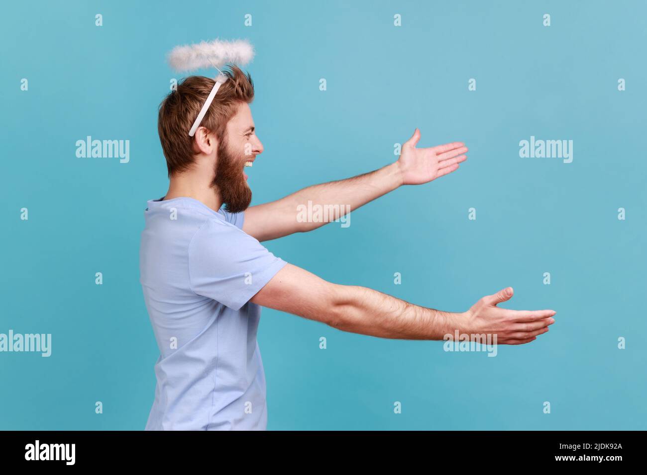 Side view of excited angelic man with holy nimbus on head standing ...