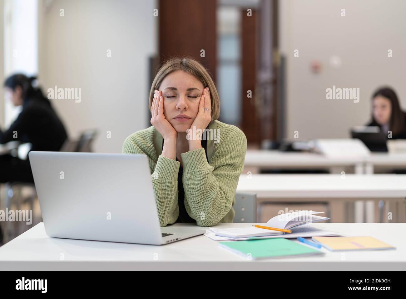 Exhausted tired middle-aged woman student falling asleep while studying at adult education class ...