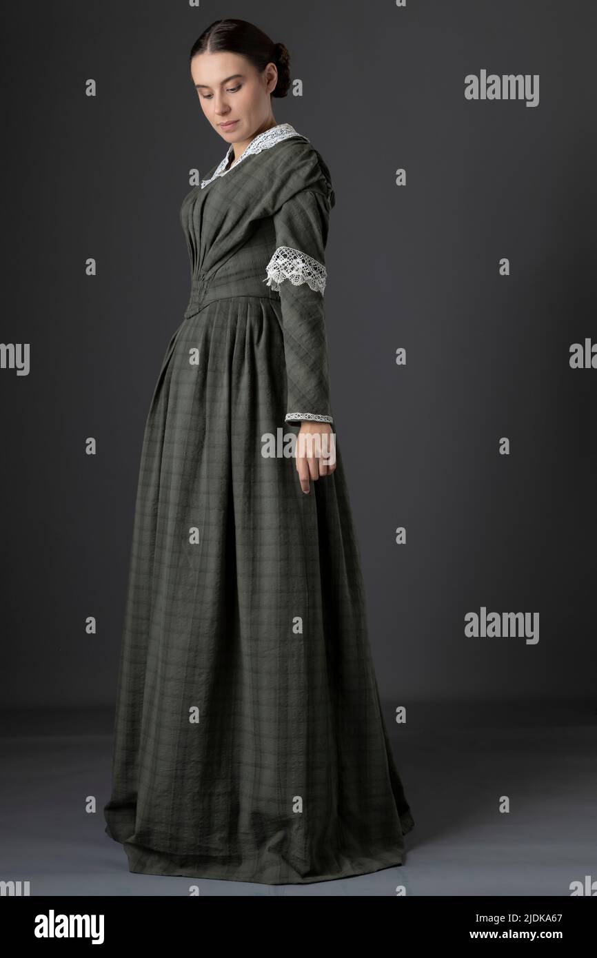 A Victorian maid servant or working class woman wearing a dark green ...