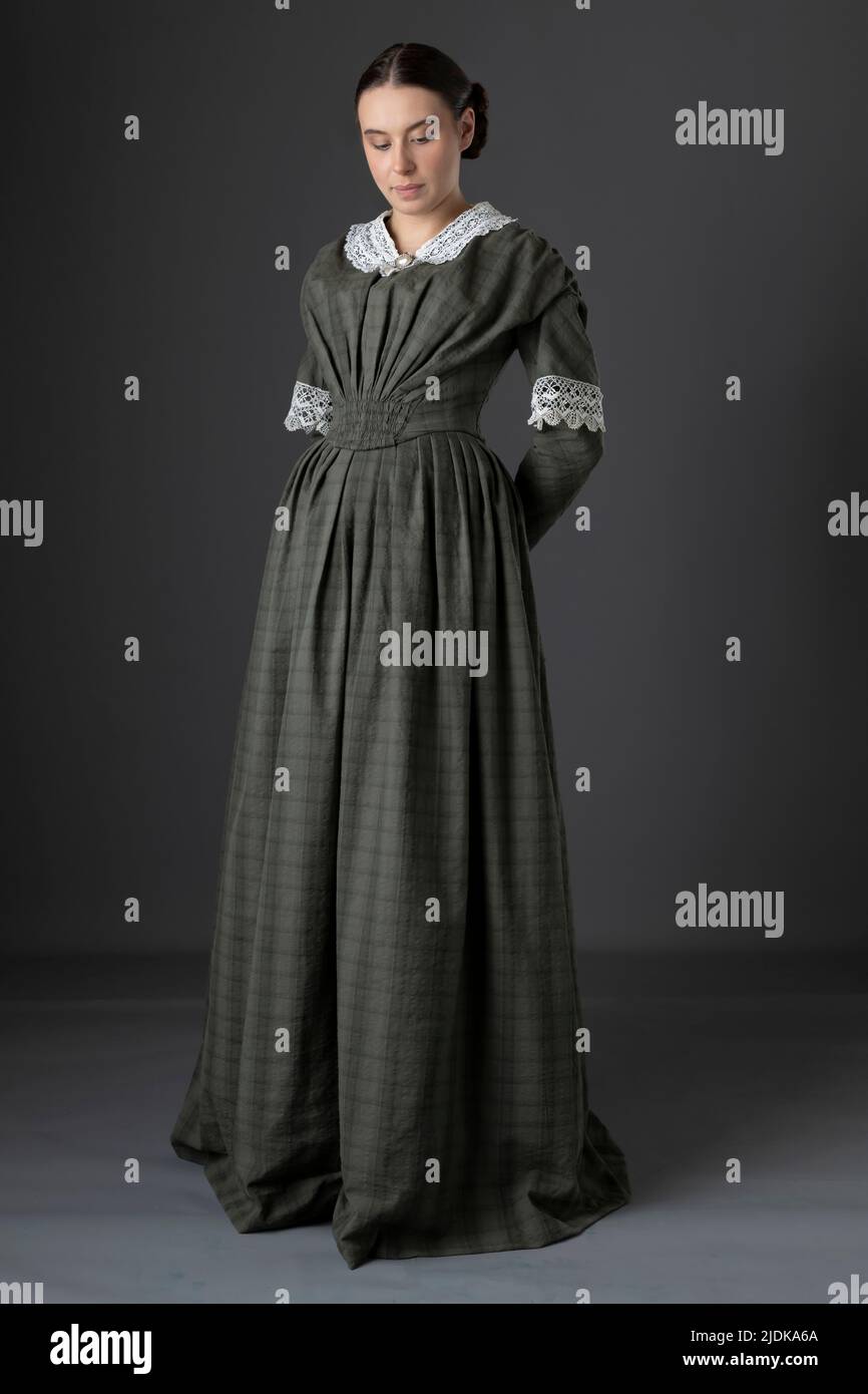 A Victorian maid servant or working class woman wearing a dark green ...