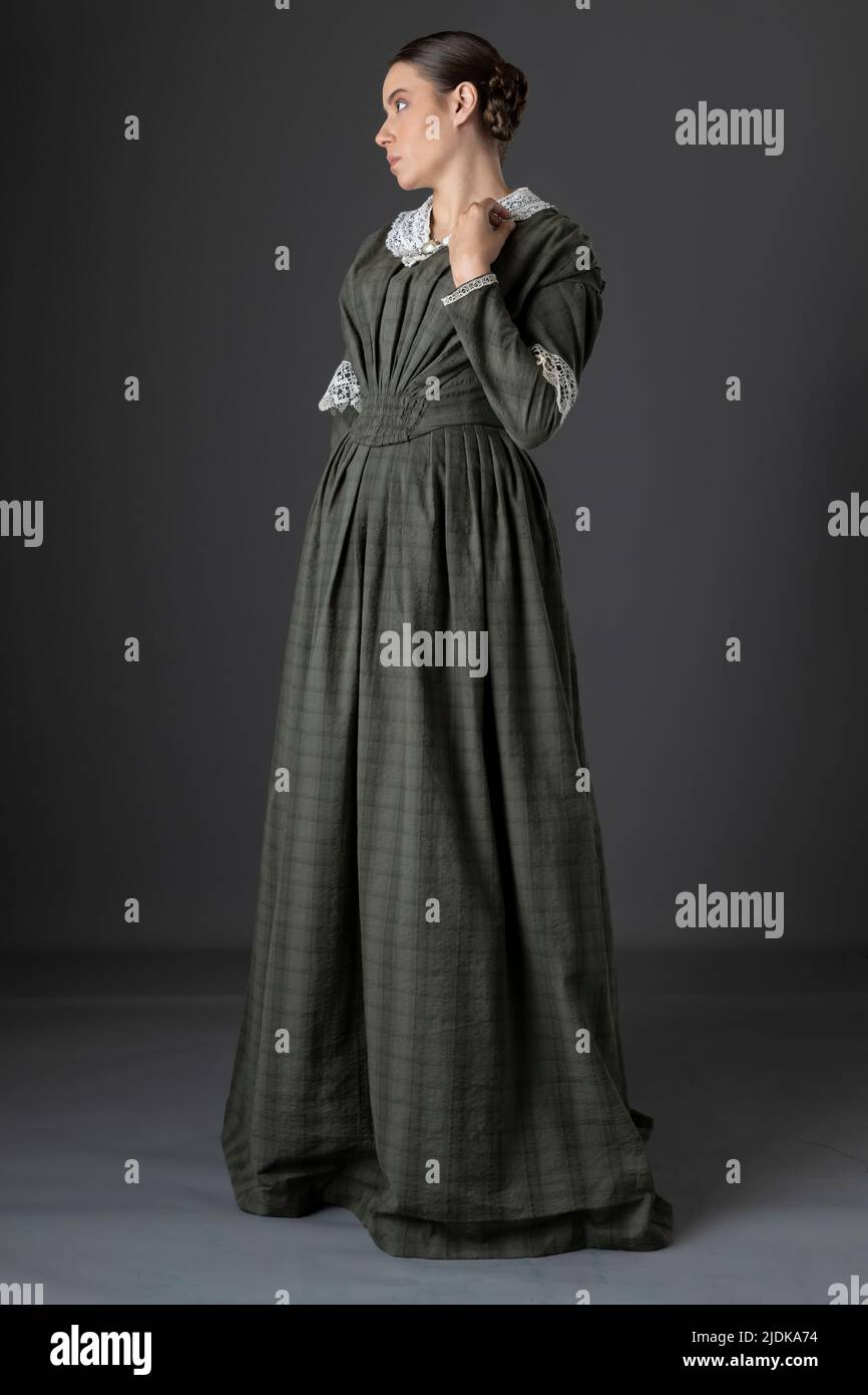 A Victorian maid servant or working class woman wearing a dark green ...