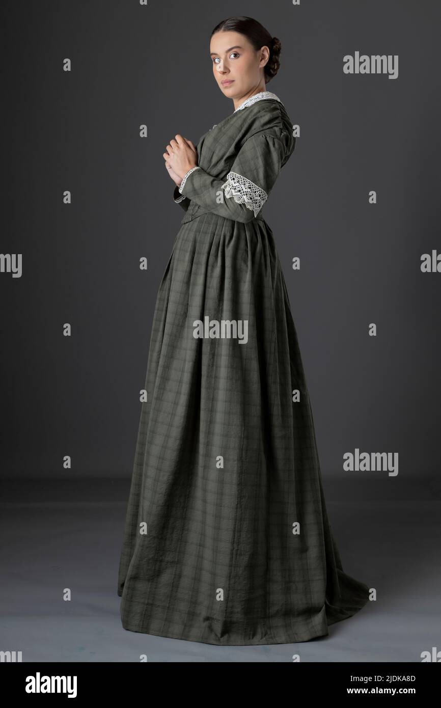 A Victorian maid servant or working class woman wearing a dark green ...