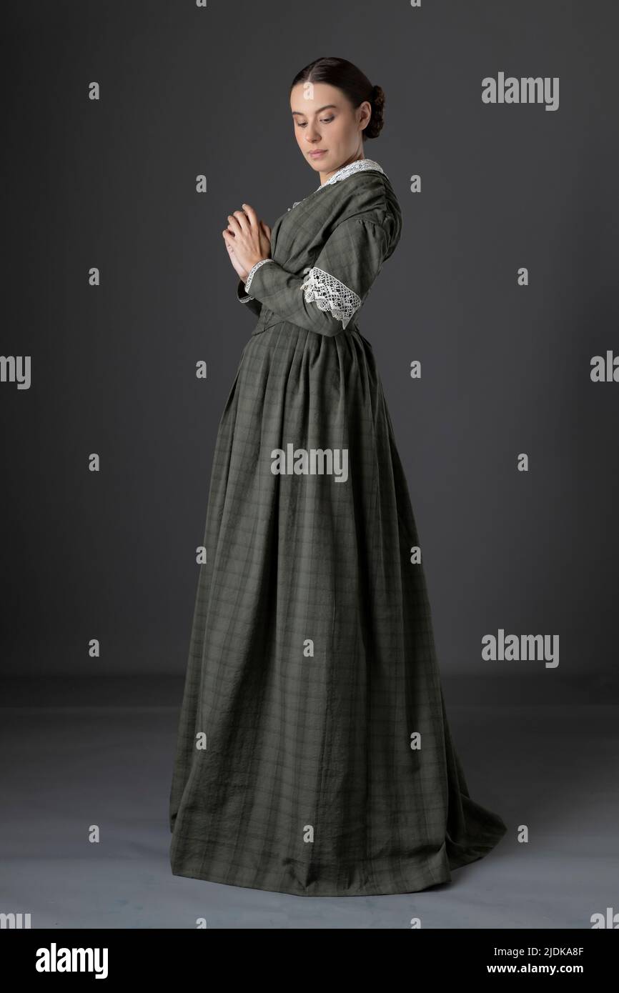 A Victorian maid servant or working class woman wearing a dark green ...