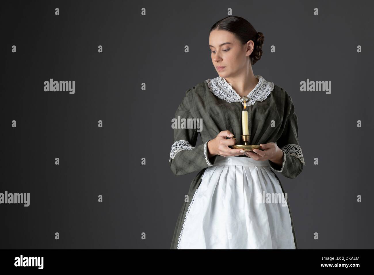A Victorian maid servant or working class woman wearing a dark green ...