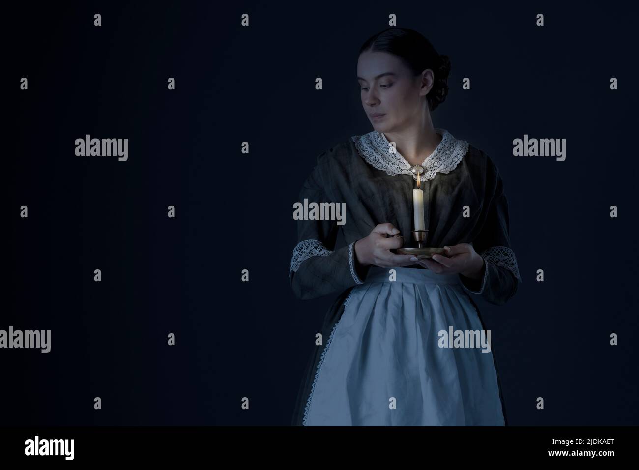 A Victorian maid servant or working class woman wearing a dark green ...