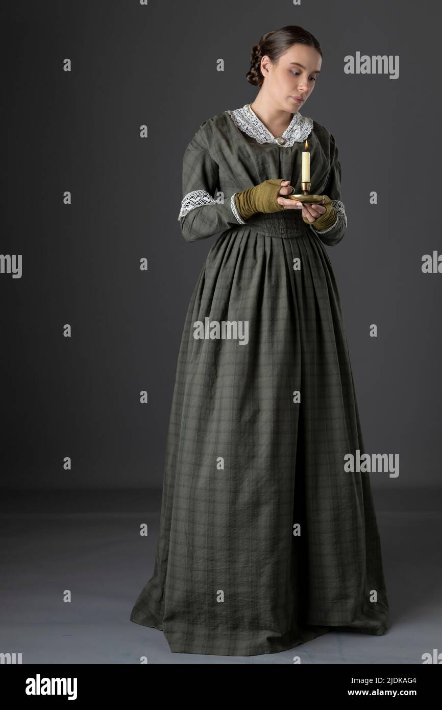 A Victorian maid servant or working class woman wearing a dark green ...