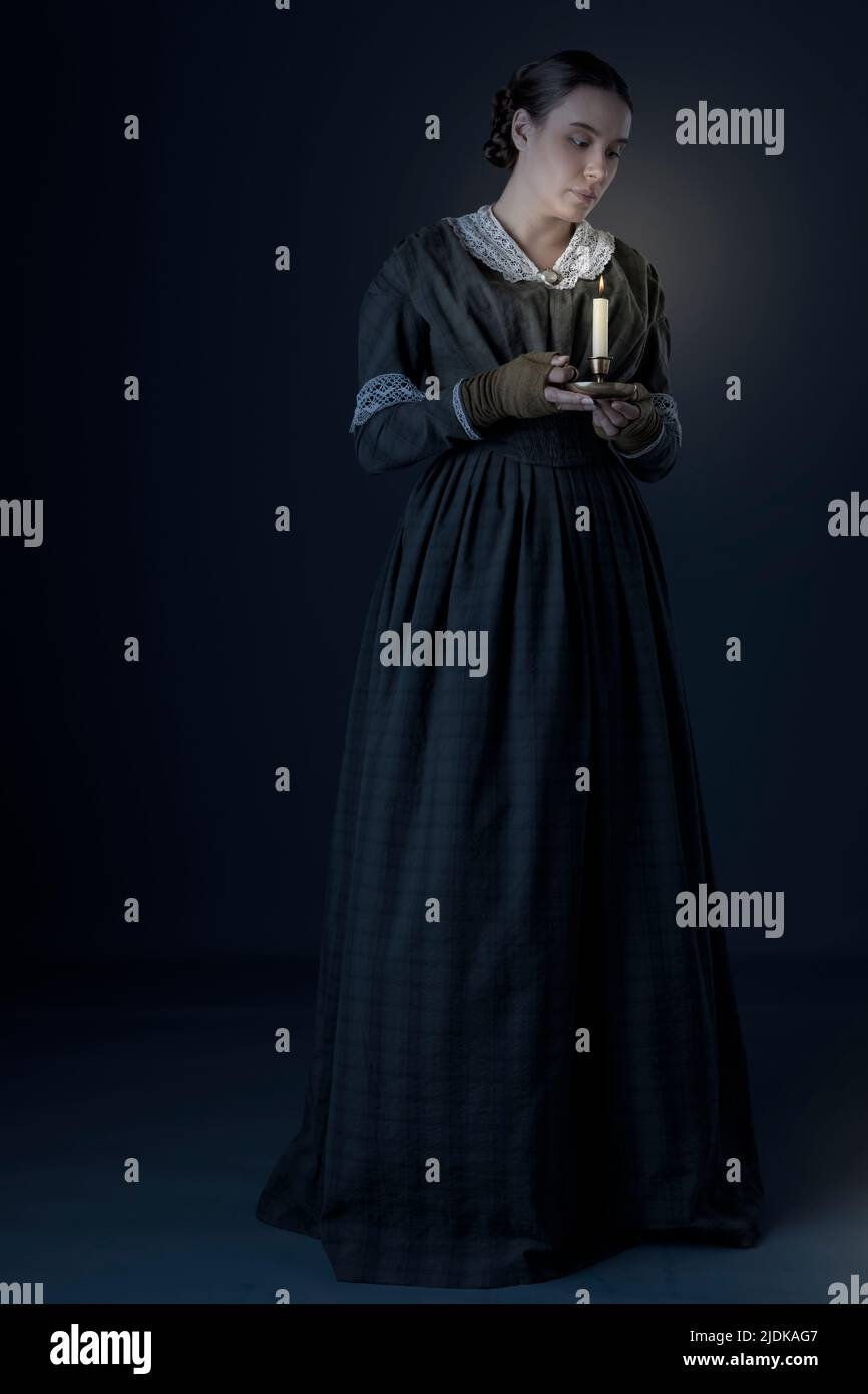 A Victorian maid servant or working class woman wearing a dark green ...