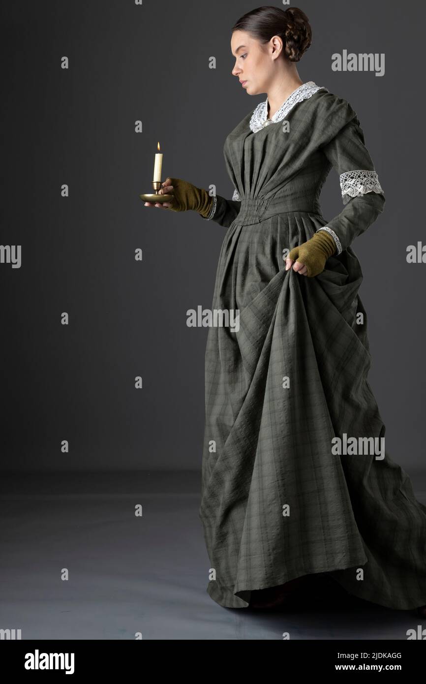 A Victorian maid servant or working class woman wearing a dark green ...