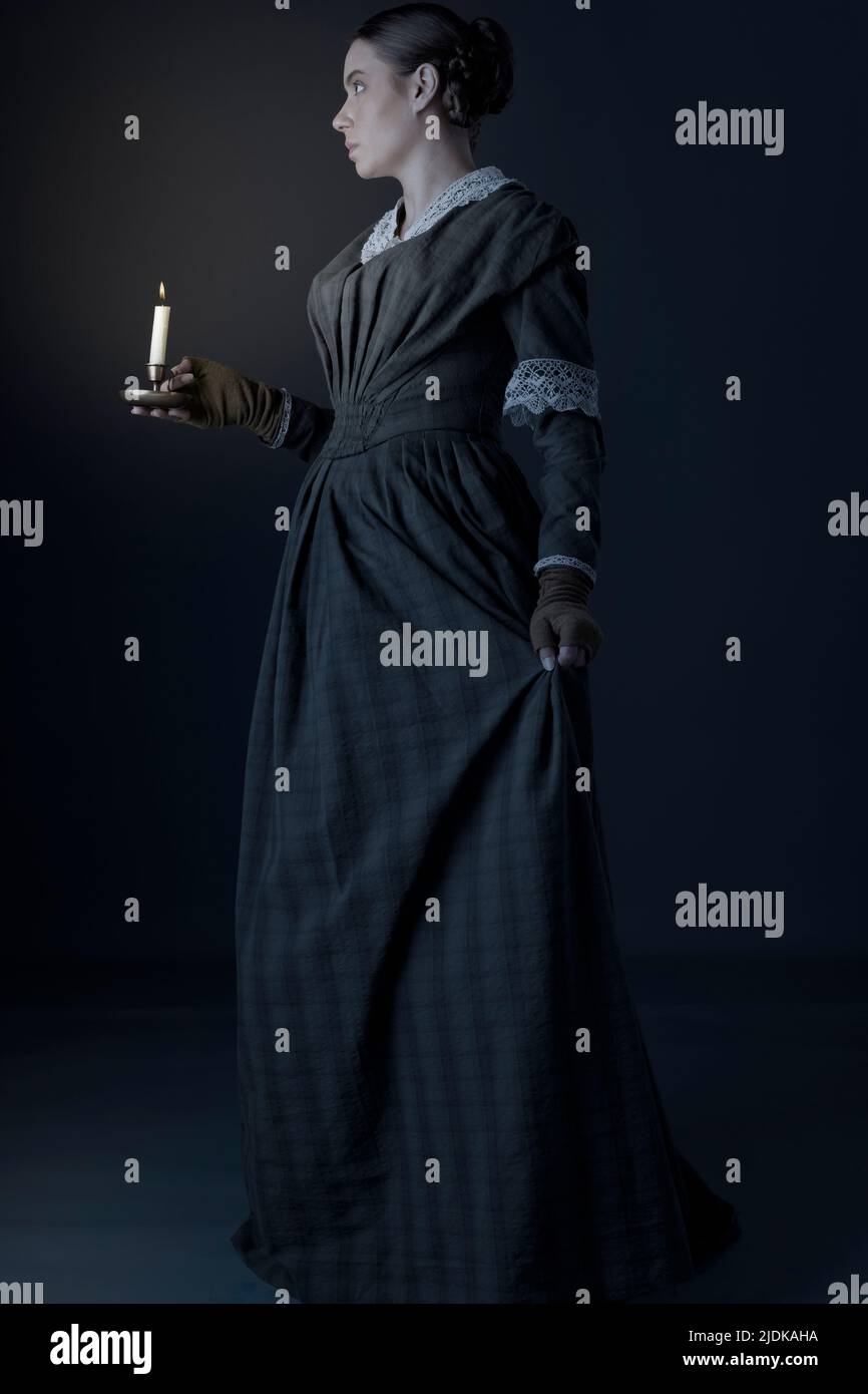 A Victorian maid servant or working class woman wearing a dark green ...