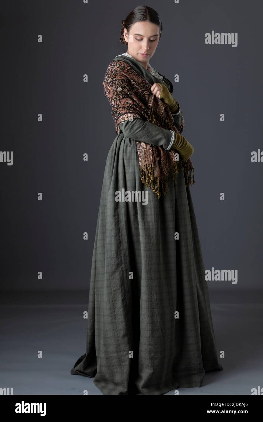 A Victorian maid servant or working class woman wearing a dark green ...