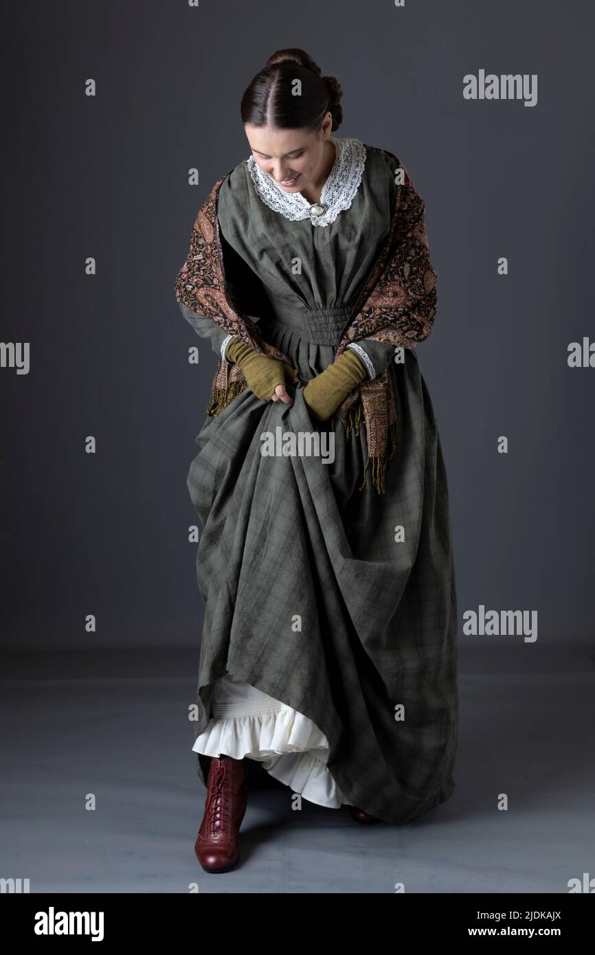 A Victorian maid servant or working class woman wearing a dark green ...