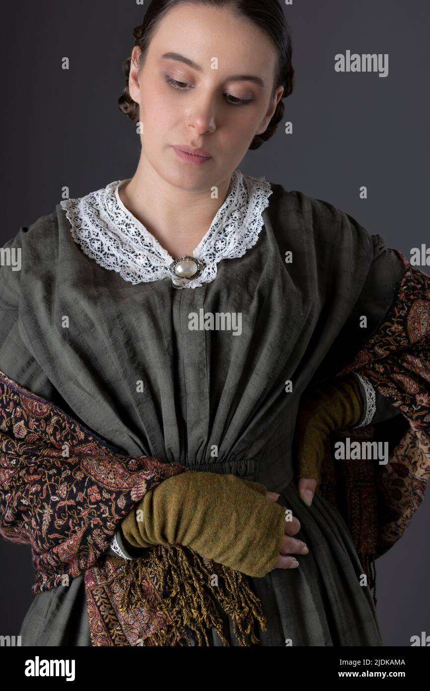 A Victorian maid servant or working class woman wearing a dark green ...