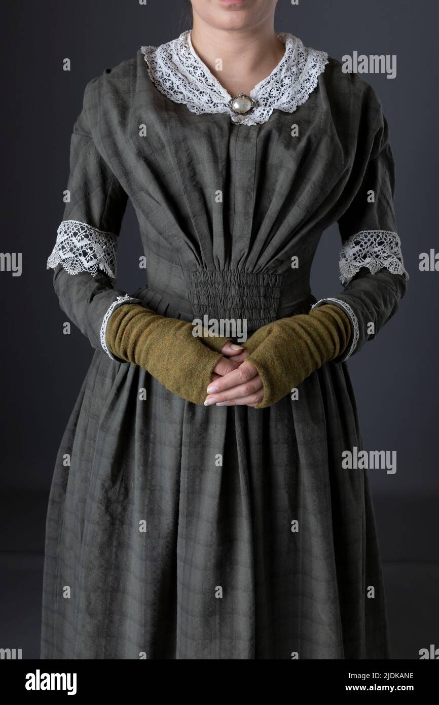 A Victorian maid servant or working class woman wearing a dark green ...