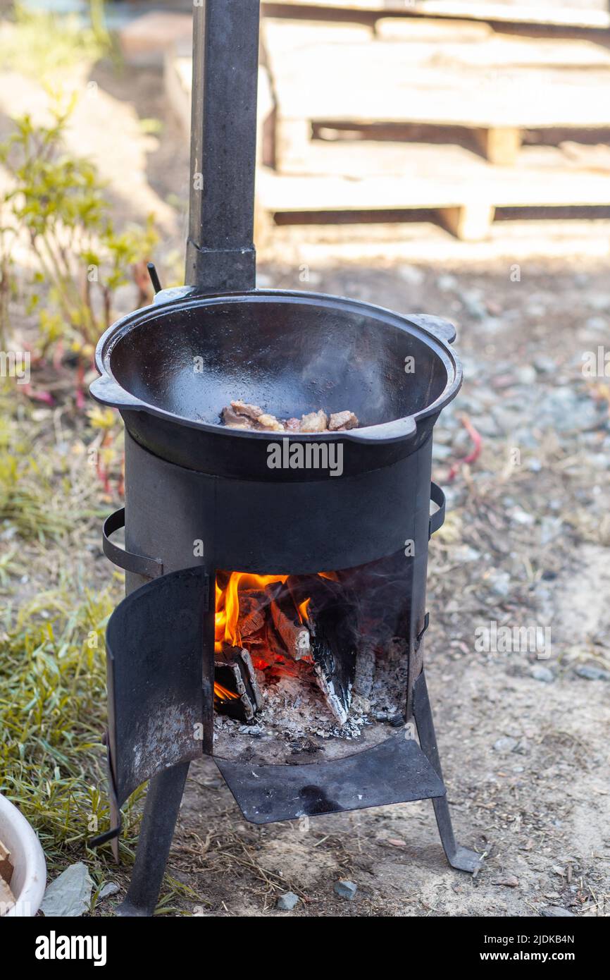 Cooking food or pilaf in a cauldron on fire. Cooking in cauldron on ...