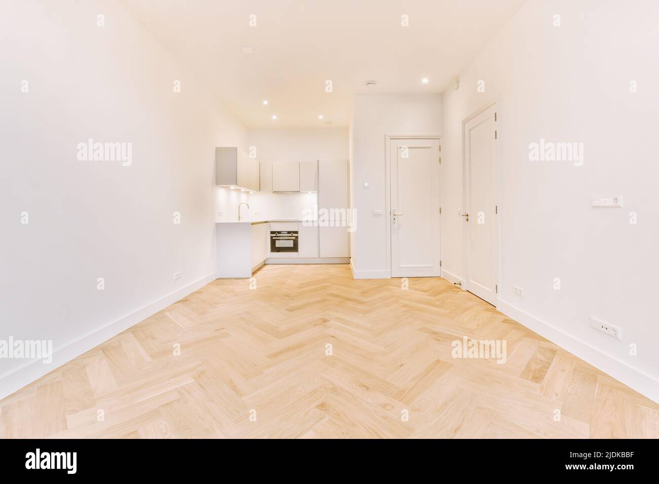 Front view of empty room with kitchen area Stock Photo - Alamy