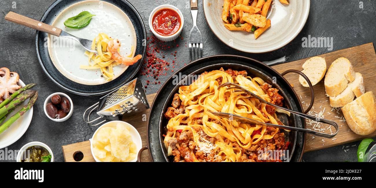 Table of italian meals on plates pasta Bolognese, ravioli, penne with ...