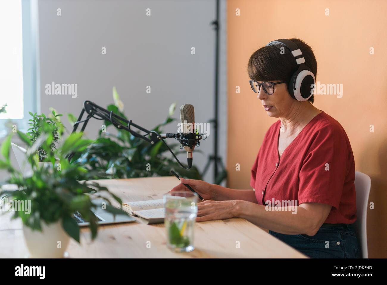 Middle-aged female radio presenter talking into the microphone and ...