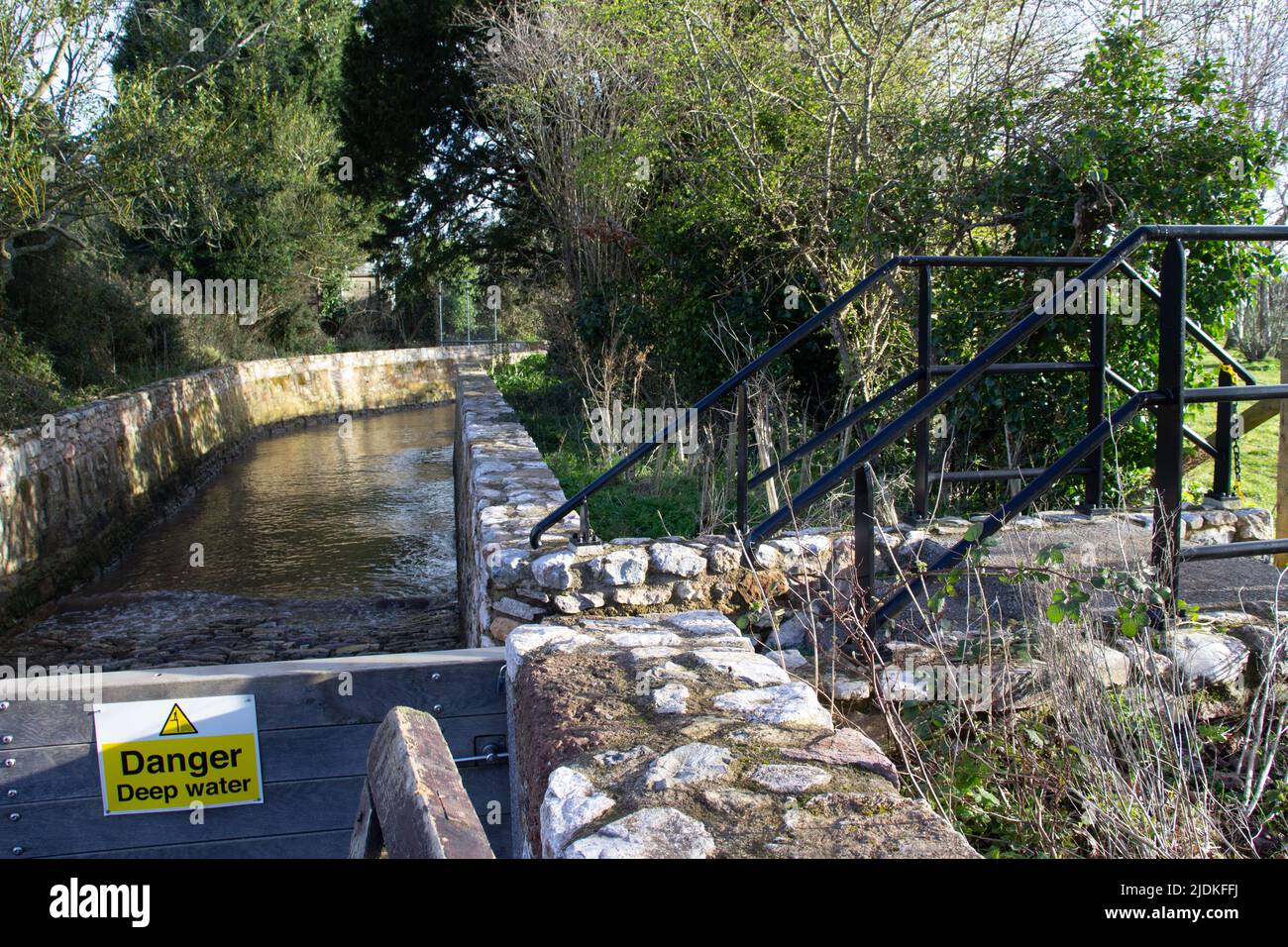 flood defence with rock walls and trees on the side and water running ...
