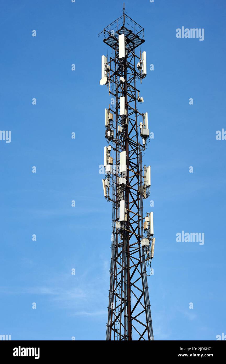cell phone tower on a blue sky background Stock Photo - Alamy