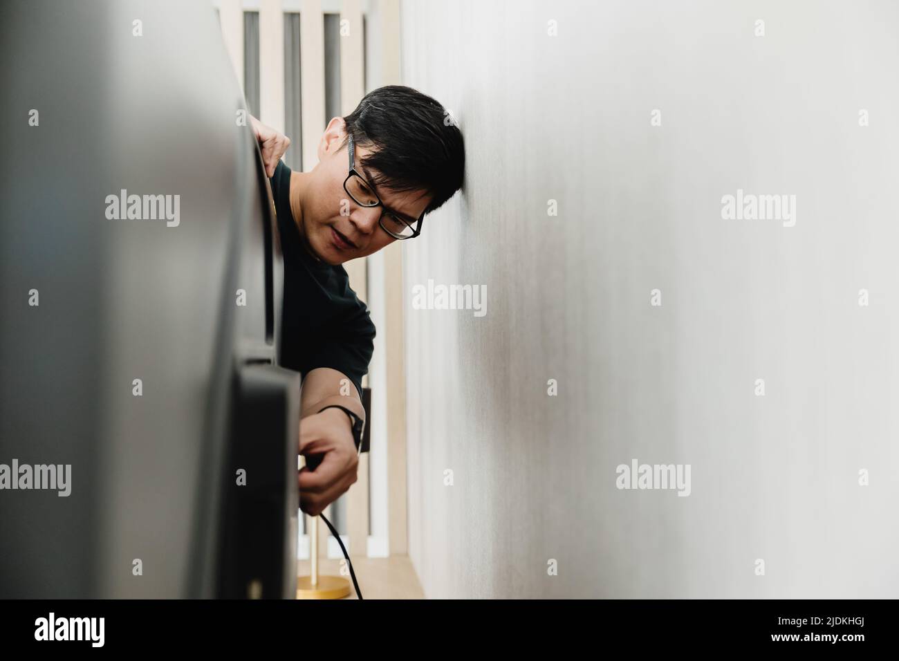 man looking fix cable connection problem of TV panel back side against ...