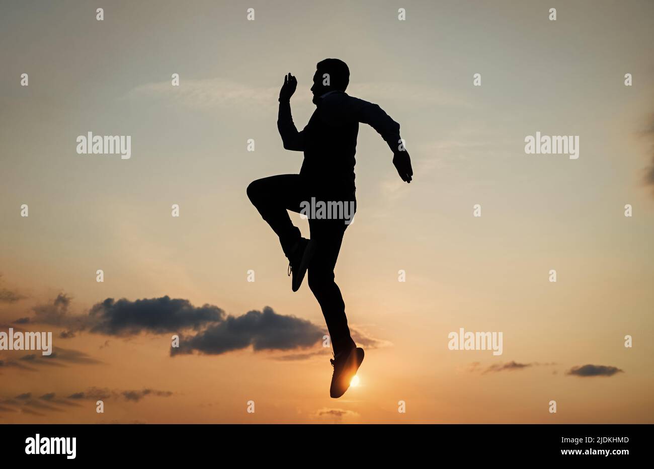 energetic man runner silhouette running to future against sunset sky ...