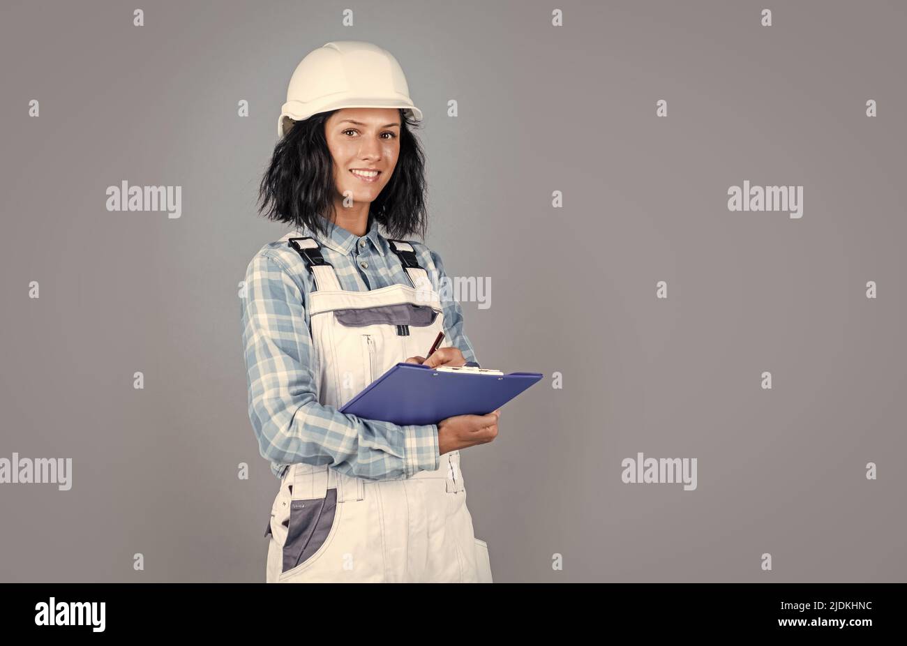 Low maintenance. engineer hold folder. young female worker on gray ...