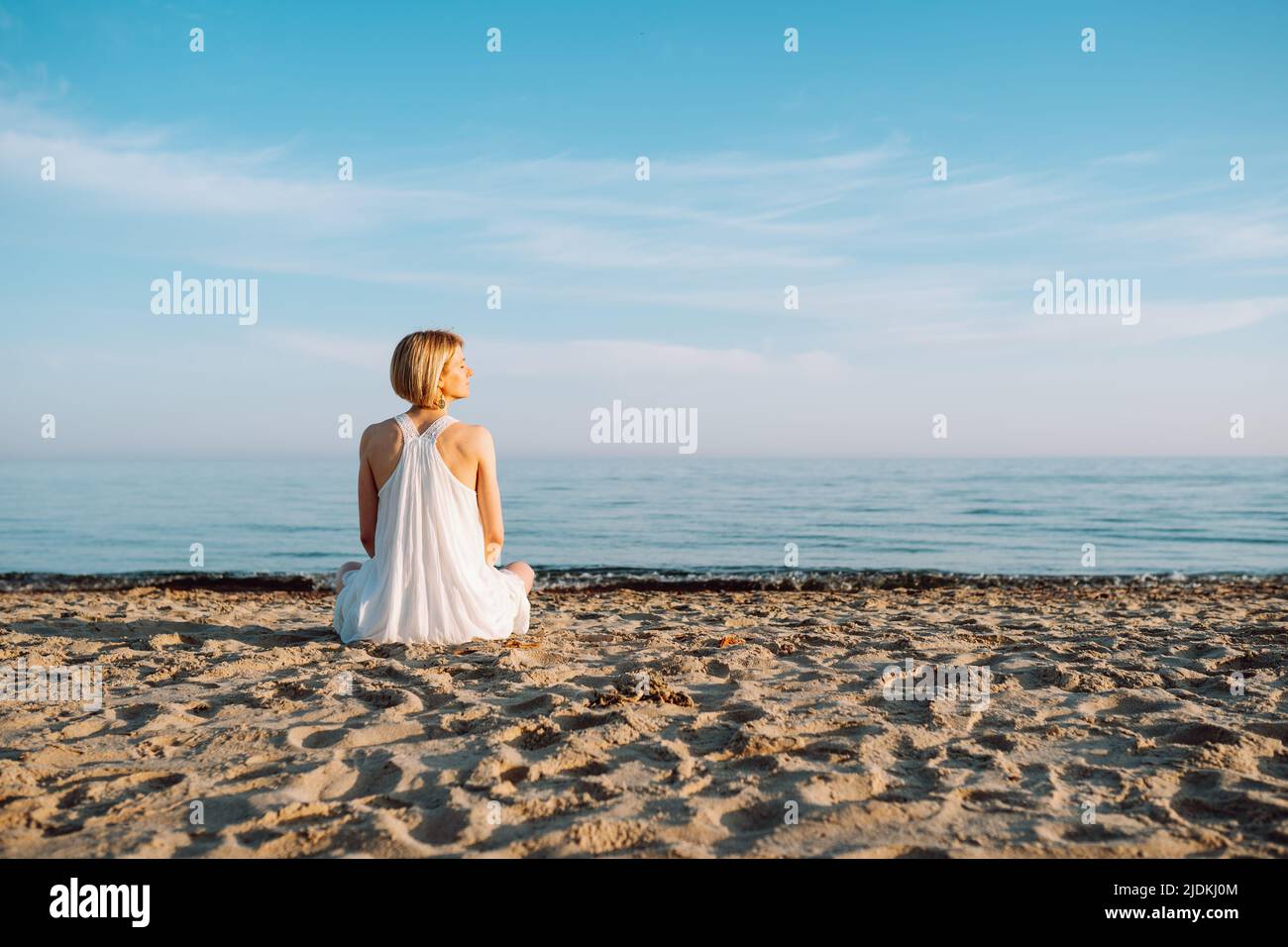 Woman sitting on beach back view hi-res stock photography and images ...