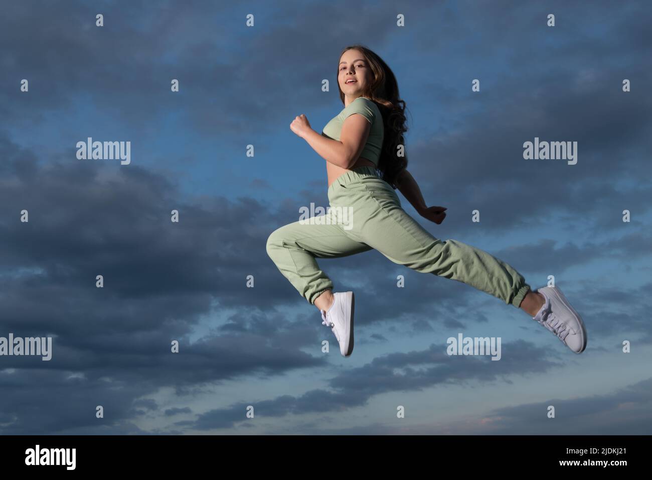 teen girl running high on sky background Stock Photo - Alamy