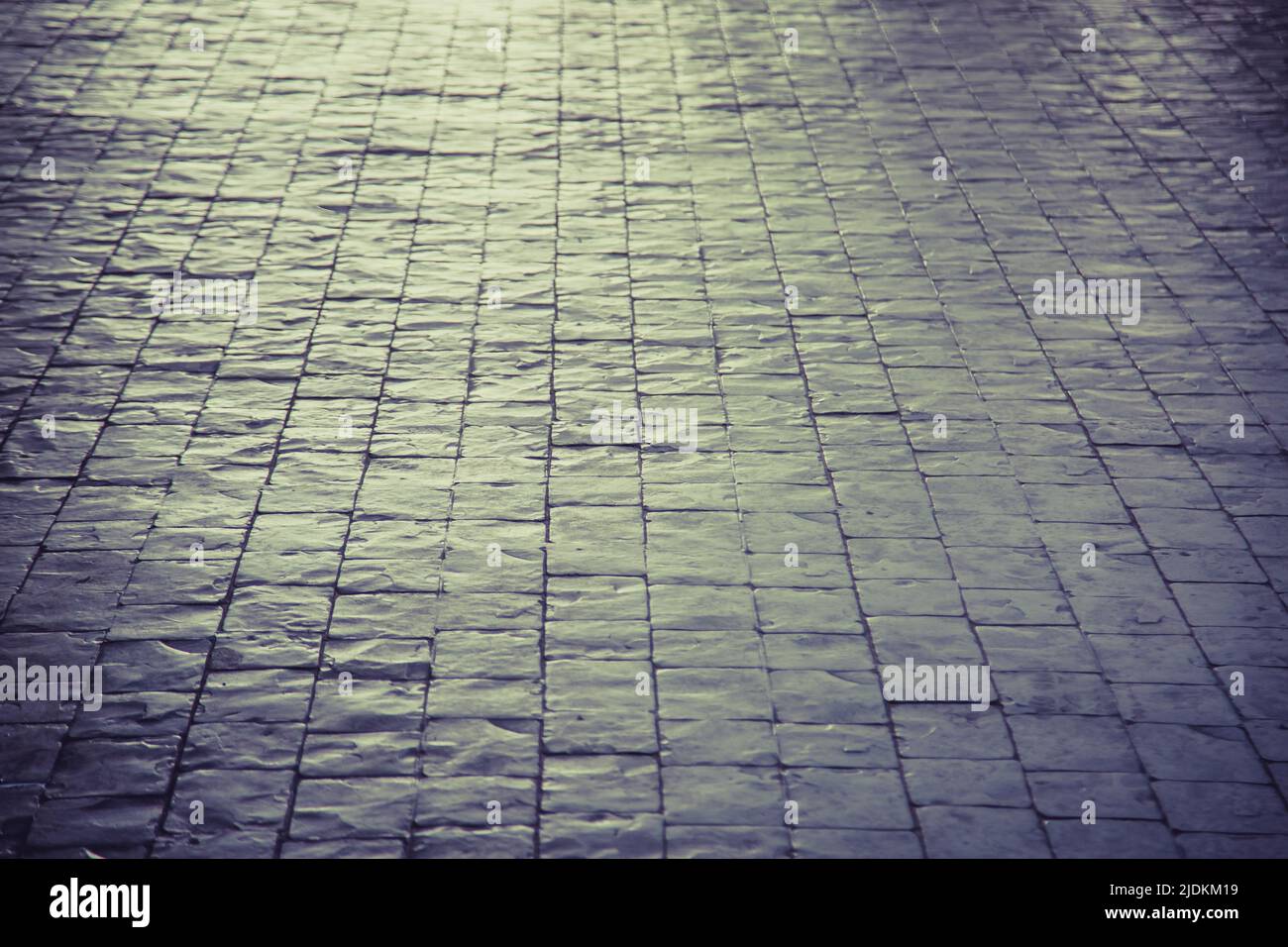 Road made of small pieces of old gray bright stone use for background ...