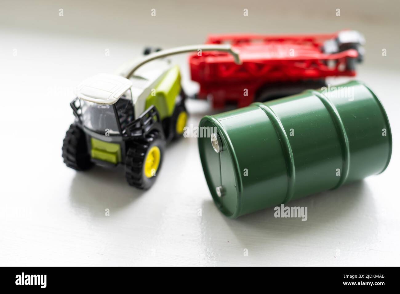 toy tractor with toy oil barrel on white background Stock Photo - Alamy